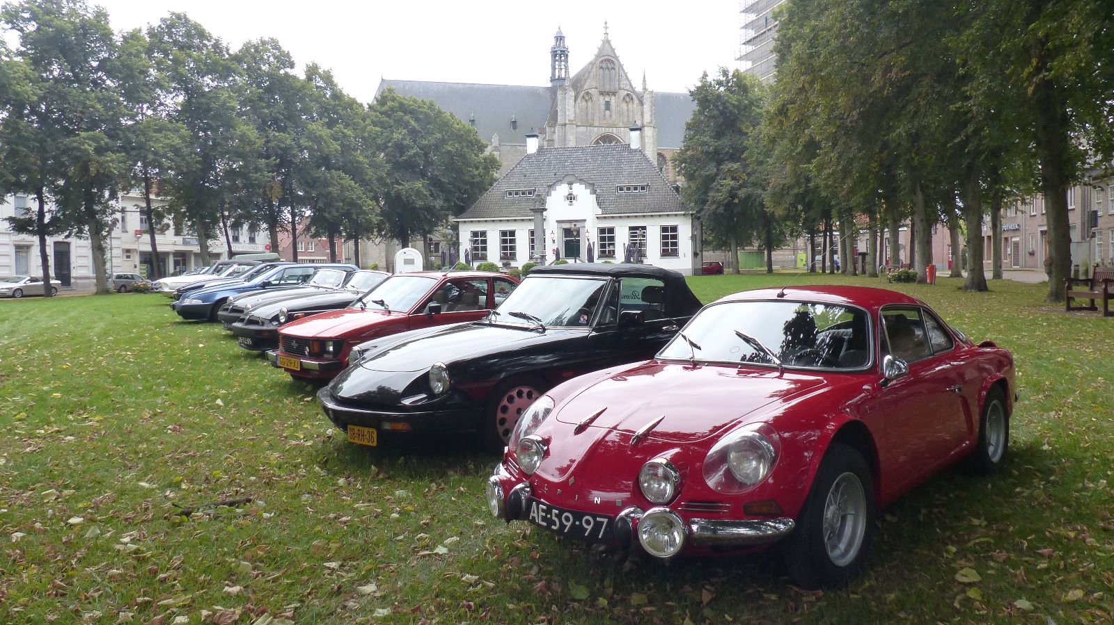 Klassieke auto's bekijken tijdens de zegening van oldtimers in Wouw